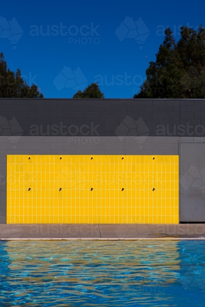 Image of Yellow tiles and outdoor showers at a swimming pool - Austockphoto