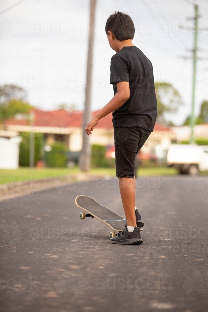 Image of Young Aboriginal boy riding a skateboard - Austockphoto