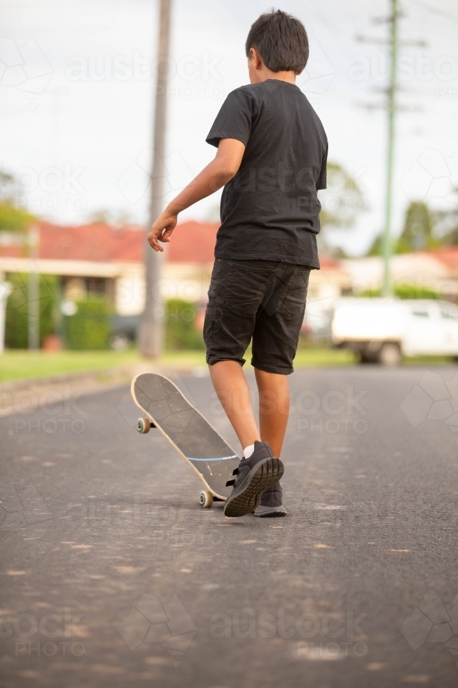 Image of Young Aboriginal boy riding a skateboard - Austockphoto
