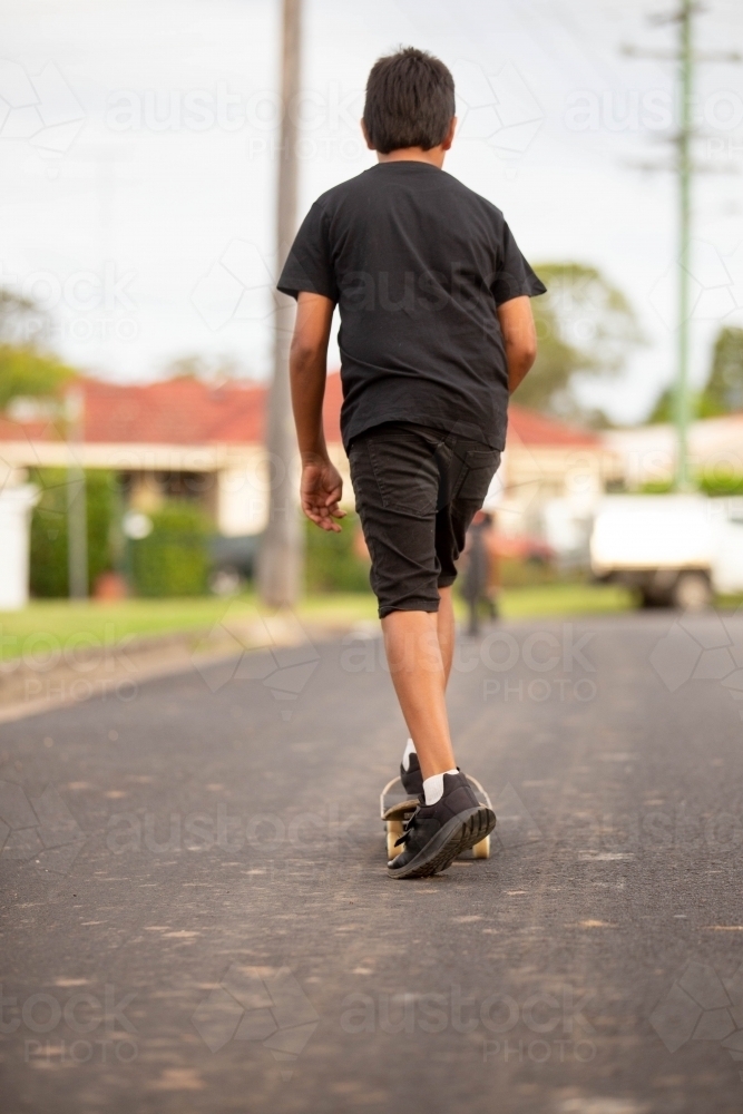 Image of Young Aboriginal boy riding a skateboard - Austockphoto