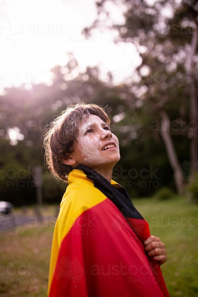 Image of Young Aboriginal boy wearing the Aboriginal flag and smiling ...