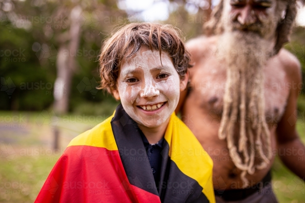 Image of Young Aboriginal boy wearing the Aboriginal flag around his ...