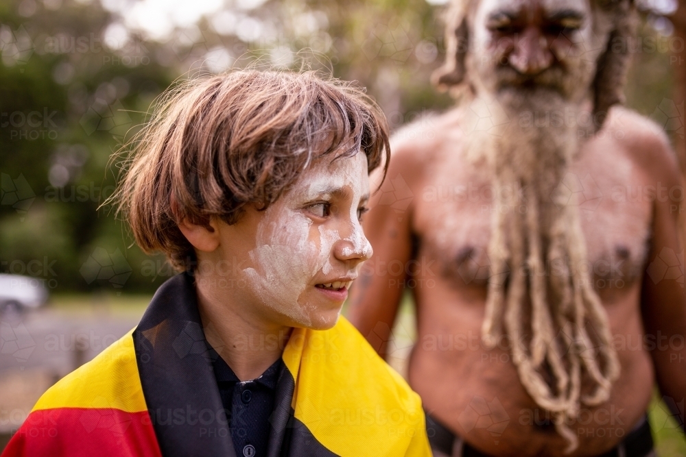 Image of Young Aboriginal boy wearing the Aboriginal flag walking in ...