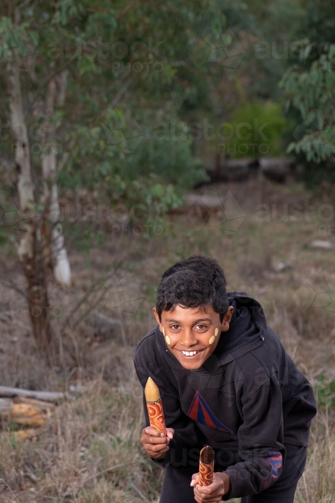 Image of Young Aboriginal Boy with clapstick instrument - Austockphoto