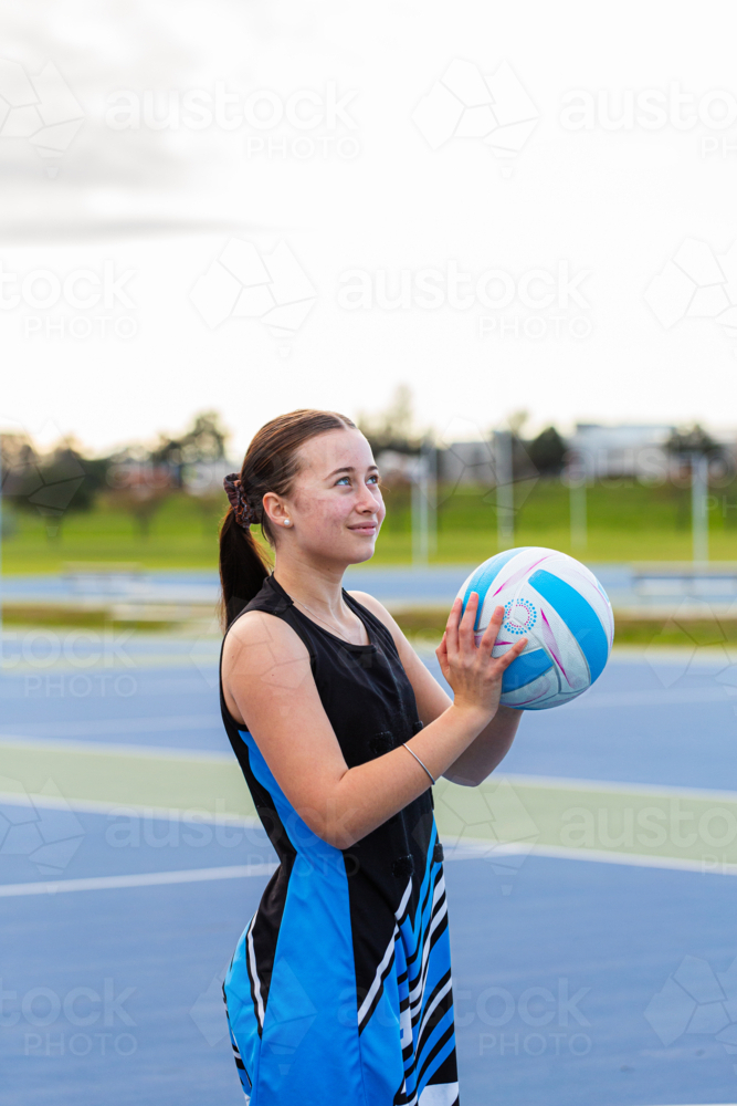 Image of Young aboriginal sports player with ball training for netball ...
