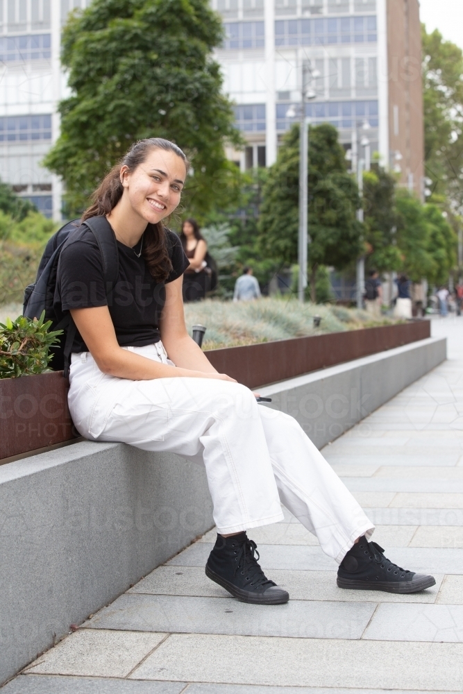 Image of Young adult aboriginal woman sitting at a university campus ...
