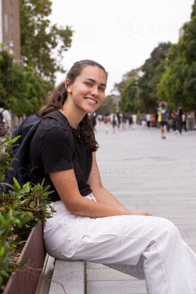Image of Young adult aboriginal woman sitting at a university campus ...