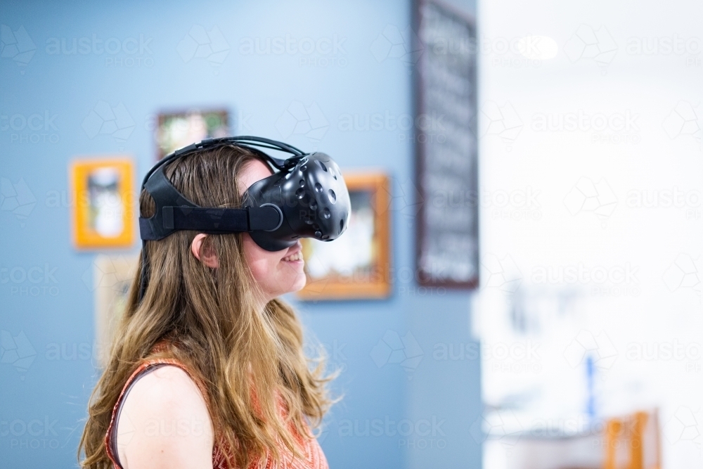 Image of Young adult looking through vr headset at virtual reality ...