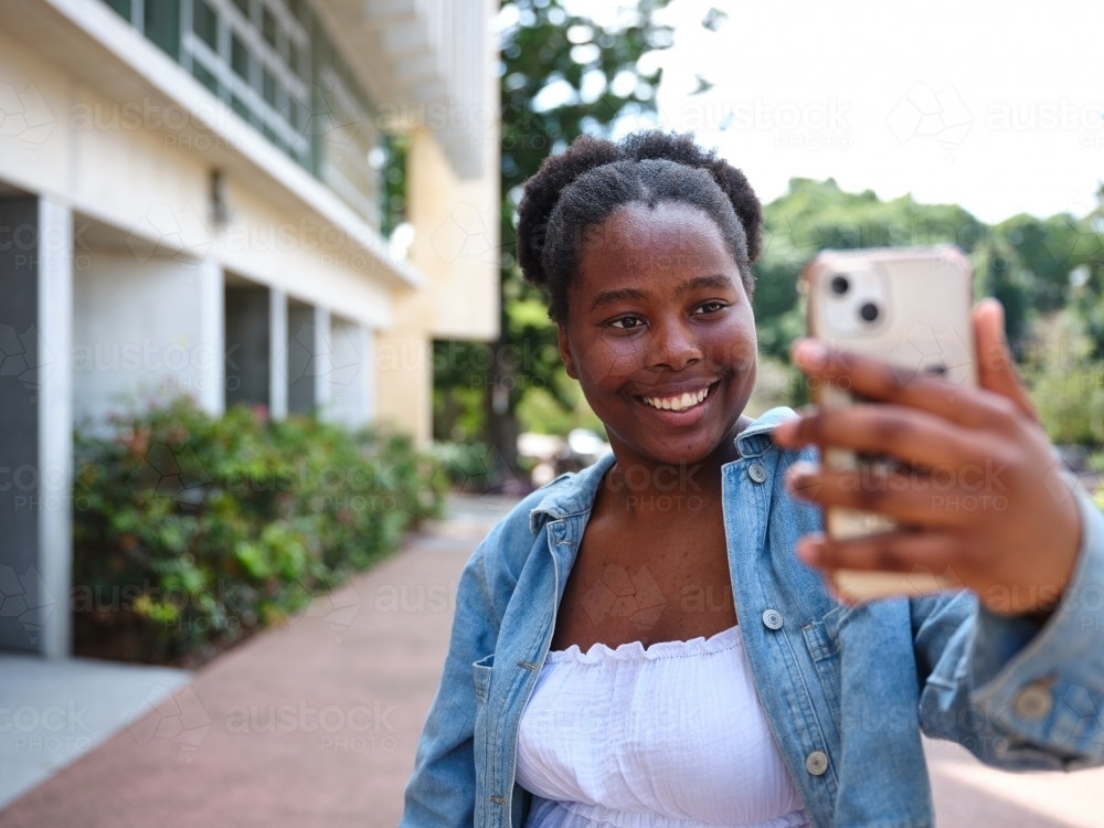 Image of Young African woman taking a selfie on a university campus ...