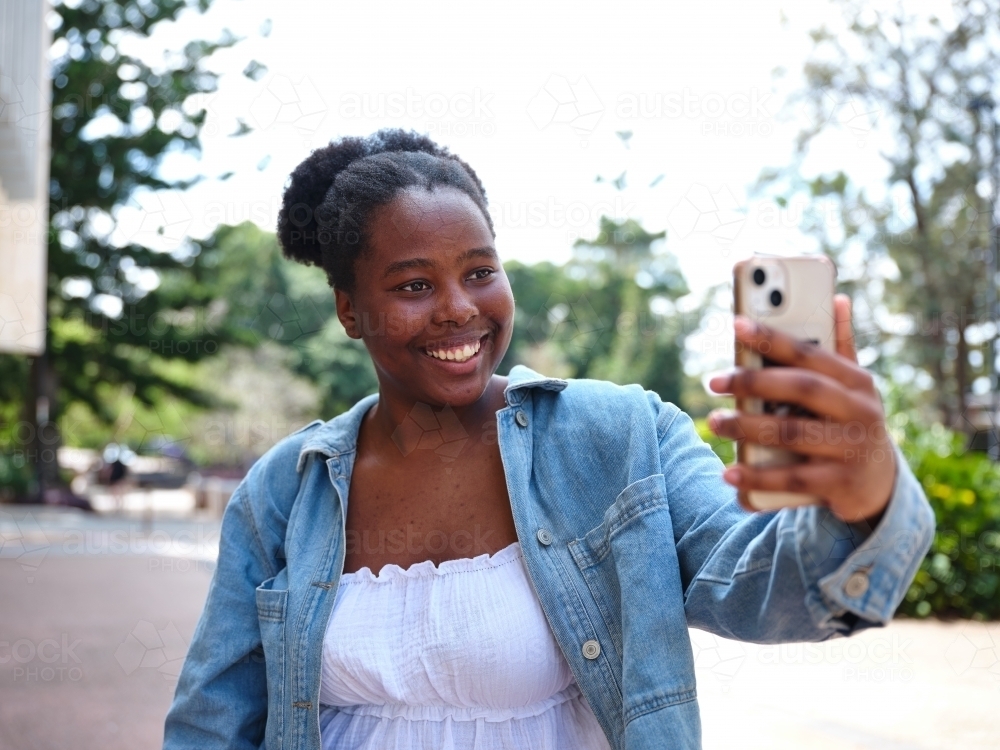 Image of Young African woman taking a selfie on a university campus ...