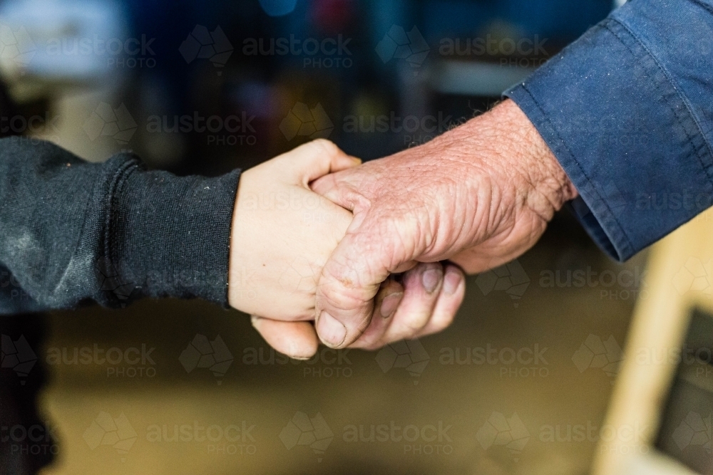 Image of Young and old person handshake - Austockphoto