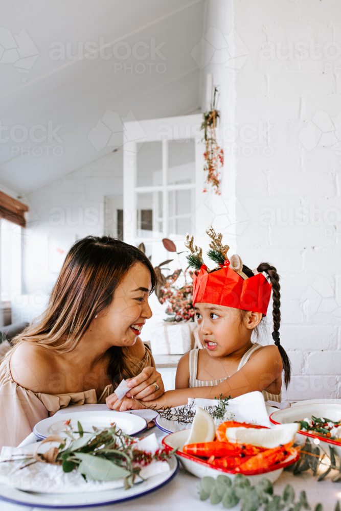 Image of Young Asian girl and mum looking at each other talking ...