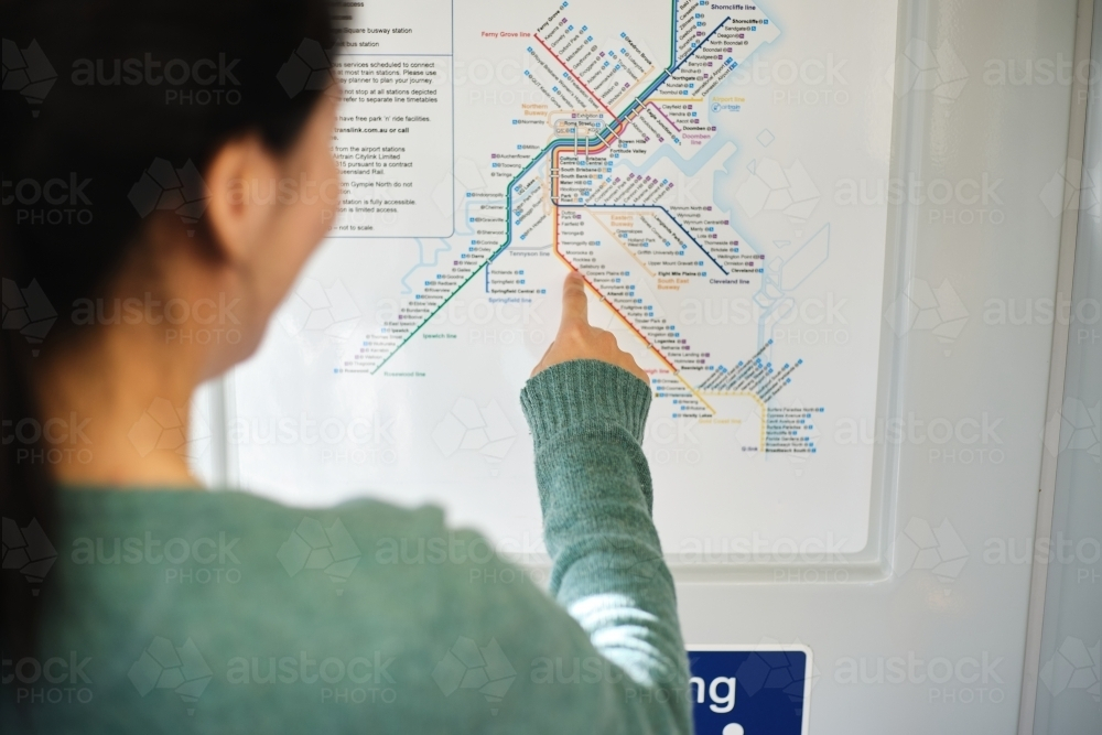 Image of Young Asian woman pointing on the train map. - Austockphoto