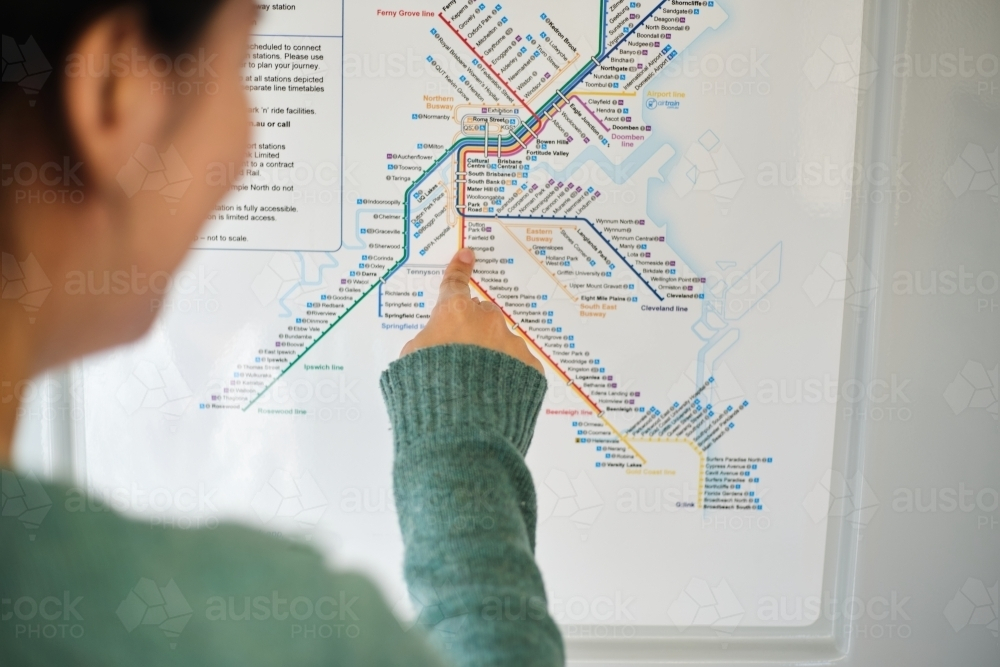 Image of Young Asian woman pointing on the train map. - Austockphoto