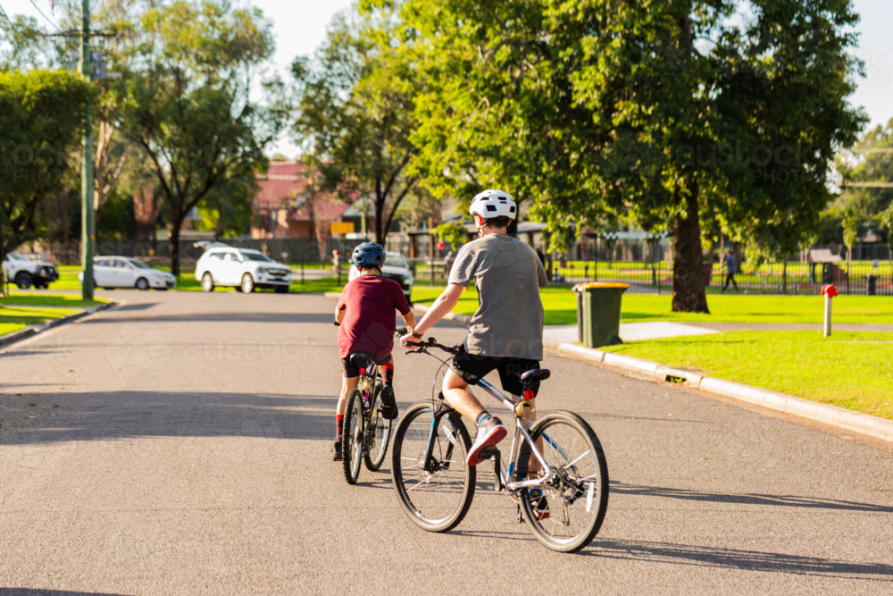 Image of Young Aussie brothers on bikes with helmets riding away on ...