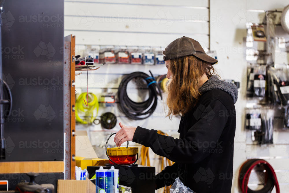 Image of young aussie mechanic working on rewiring light electronics ...