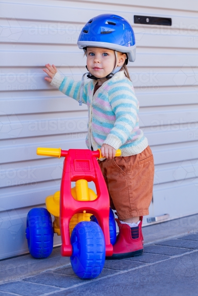Image of Young Australian toddler ready to ride tricycle outside ...