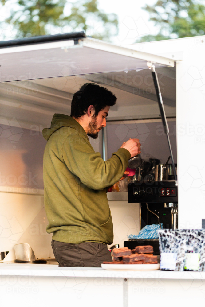Image of young barista in coffee van making warm drink at dawn on ...