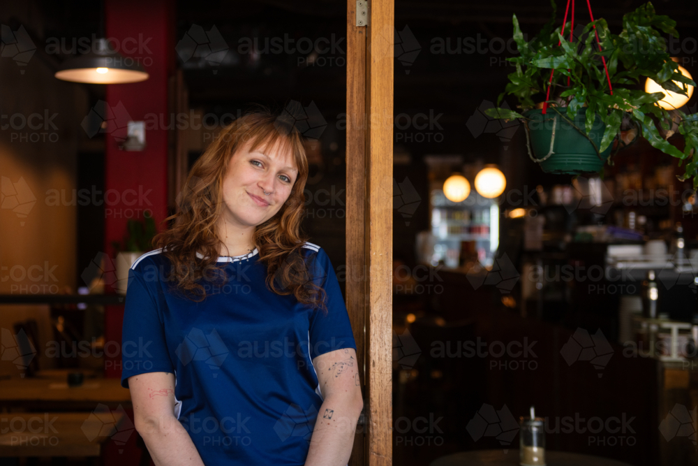 Image of young barista outside an inner city cafe - Austockphoto