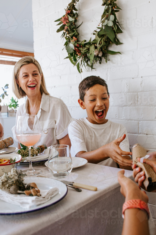 Image of Young boy excited to pull Christmas cracker - Austockphoto
