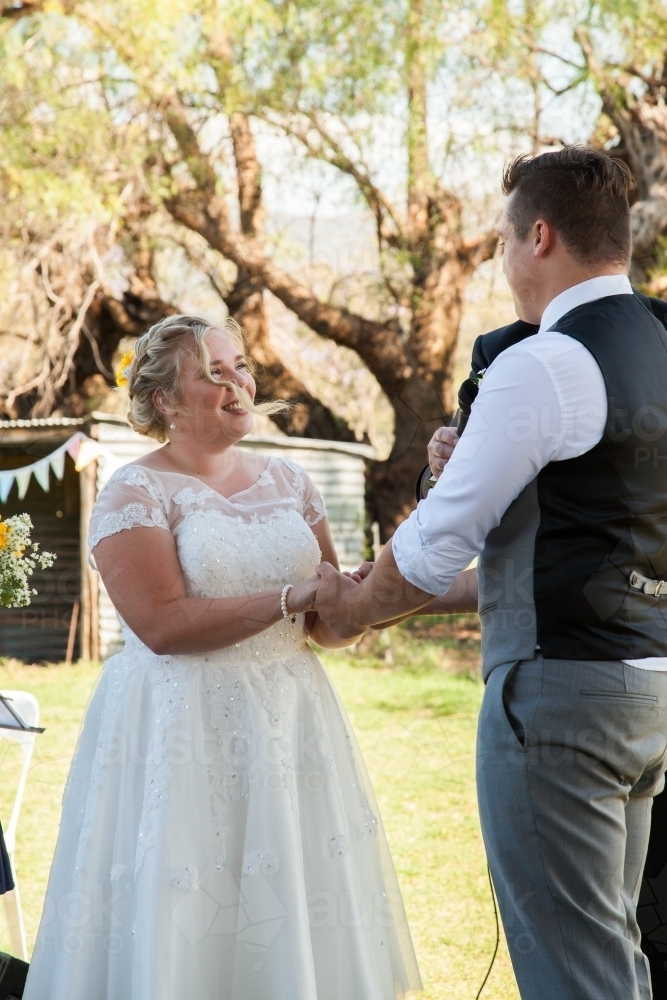 Image of Young bride and groom laughing as they get married - Austockphoto
