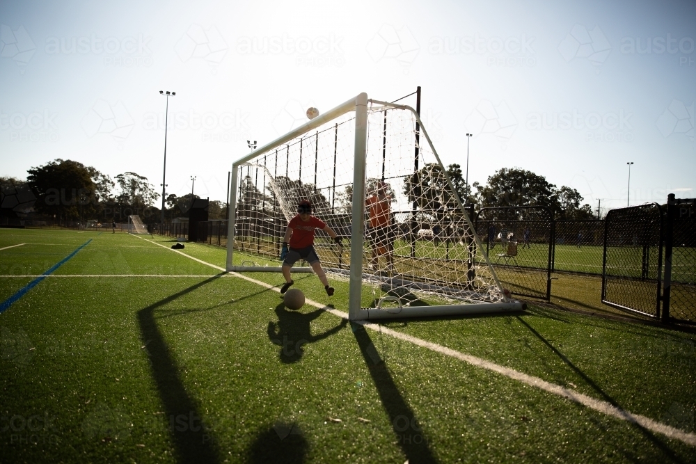 Image of young child learning how to be goalkeeper - Austockphoto