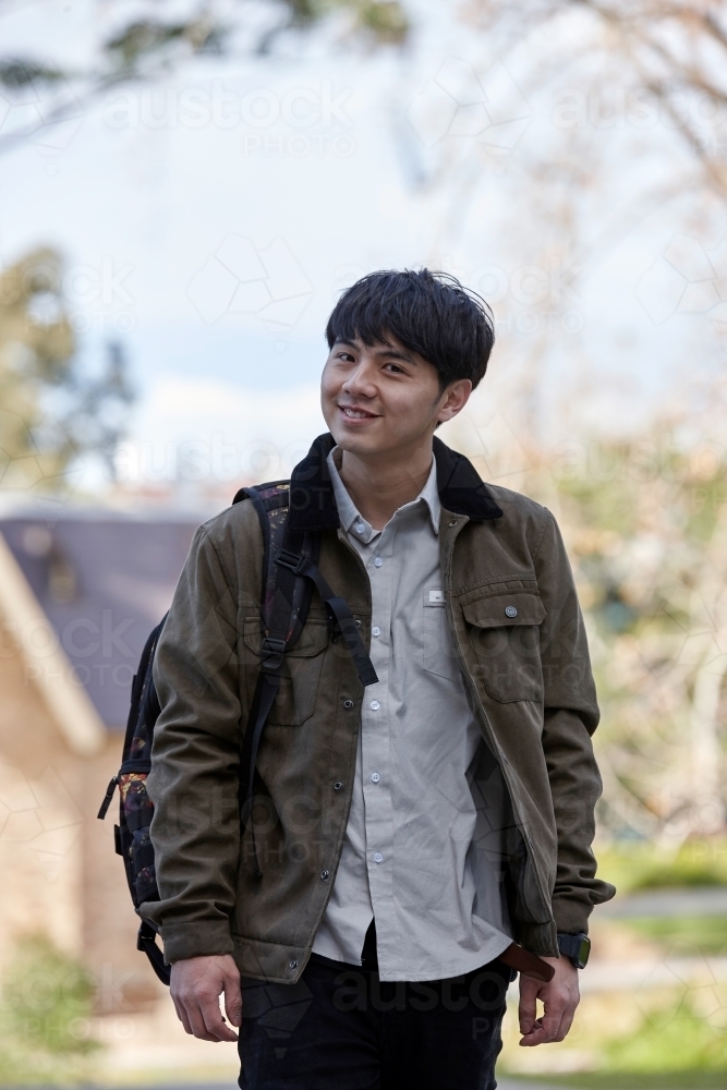 Image of Young Chinese student outdoors with backpack - Austockphoto