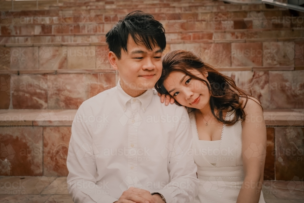 Image of Young couple sitting together on steps at Federation Square ...