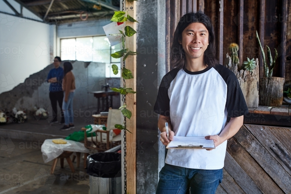 Image of Young event planner smiling whilst working on set - Austockphoto