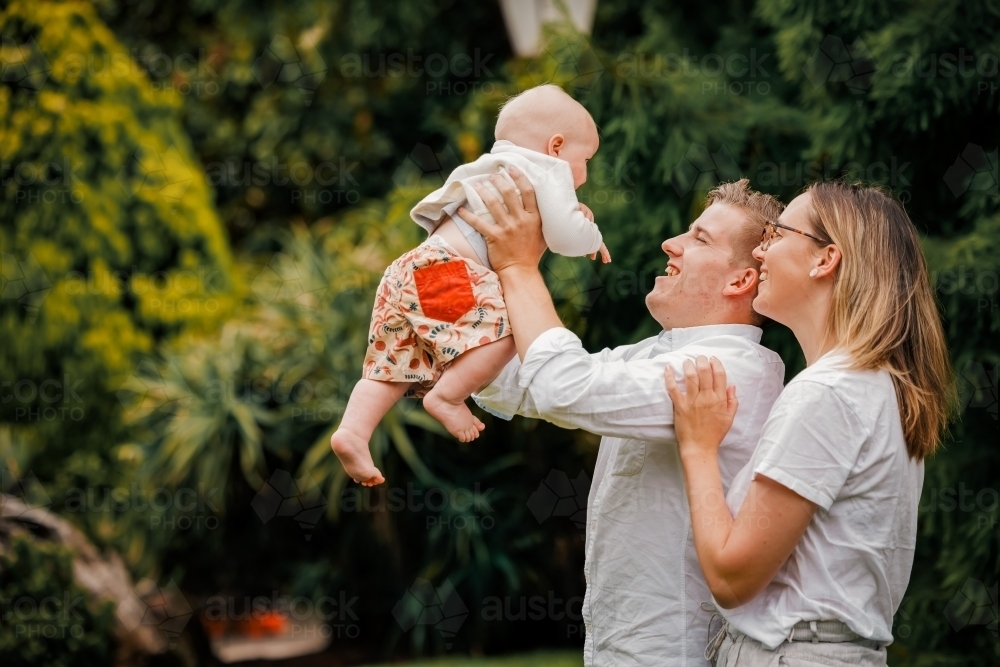 Image of Young family of 3 with small baby at the park - Austockphoto