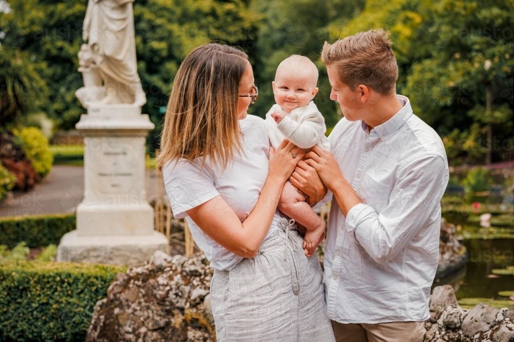 Image of Young family of 3 with small baby at the park - Austockphoto