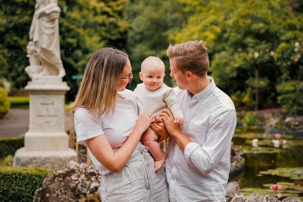 Image of Young family of 3 with small baby at the park - Austockphoto