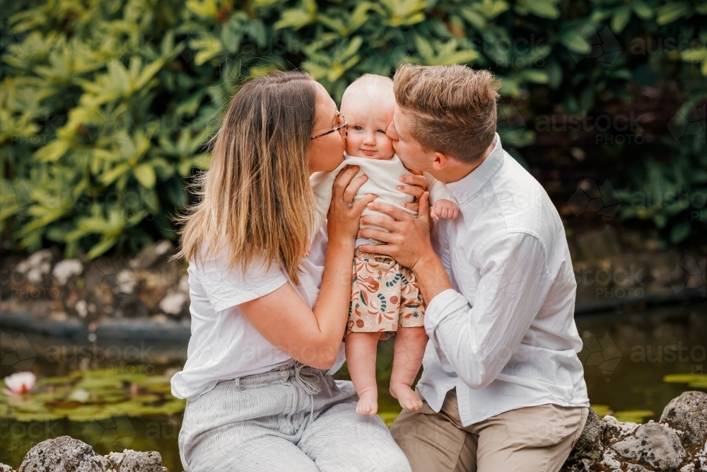 Image of Young family of 3 with small baby at the park - Austockphoto
