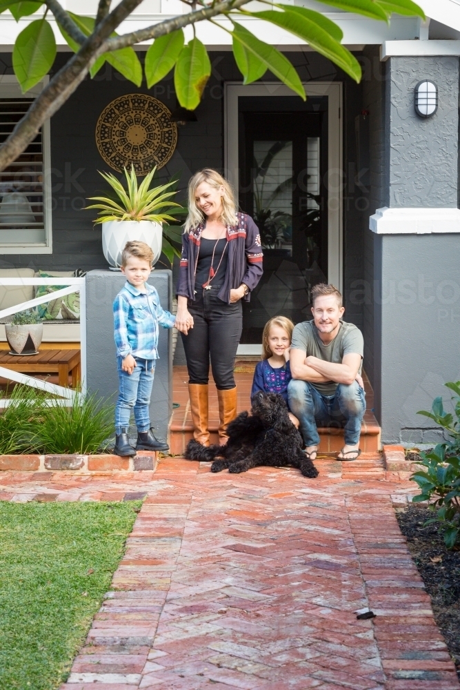 Image of Young family outside their suburban home - Austockphoto