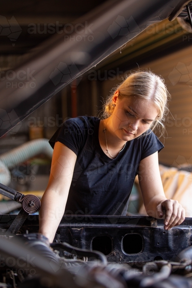Image of young female australian tradesperson mechanic working on car ...