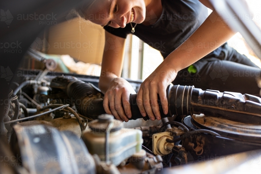 Image of young female tradesperson mechanic fixing car engine in ...