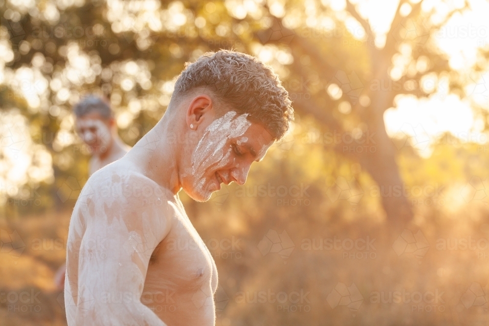 Image of Young first nations australian man looking down and smiling at ...