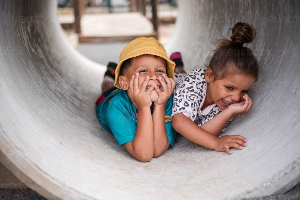 Image of Young First Nations girl and boy playing together in a tunnel ...
