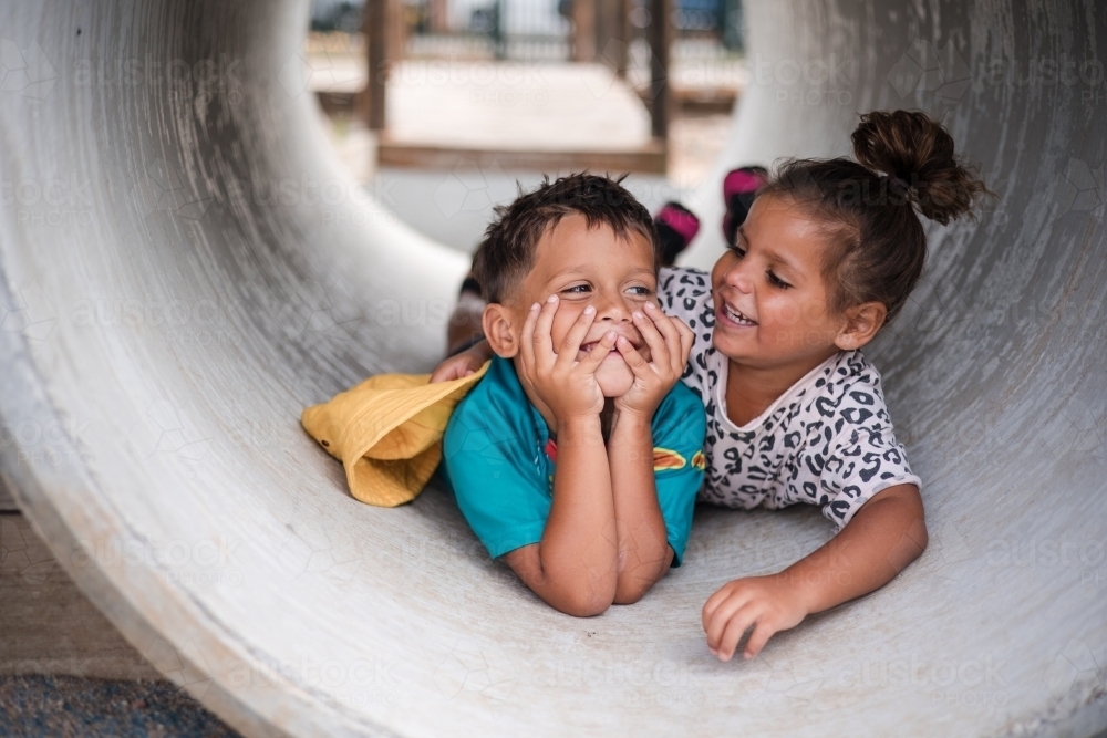 Image of Young First Nations girl and boy playing together in a tunnel ...
