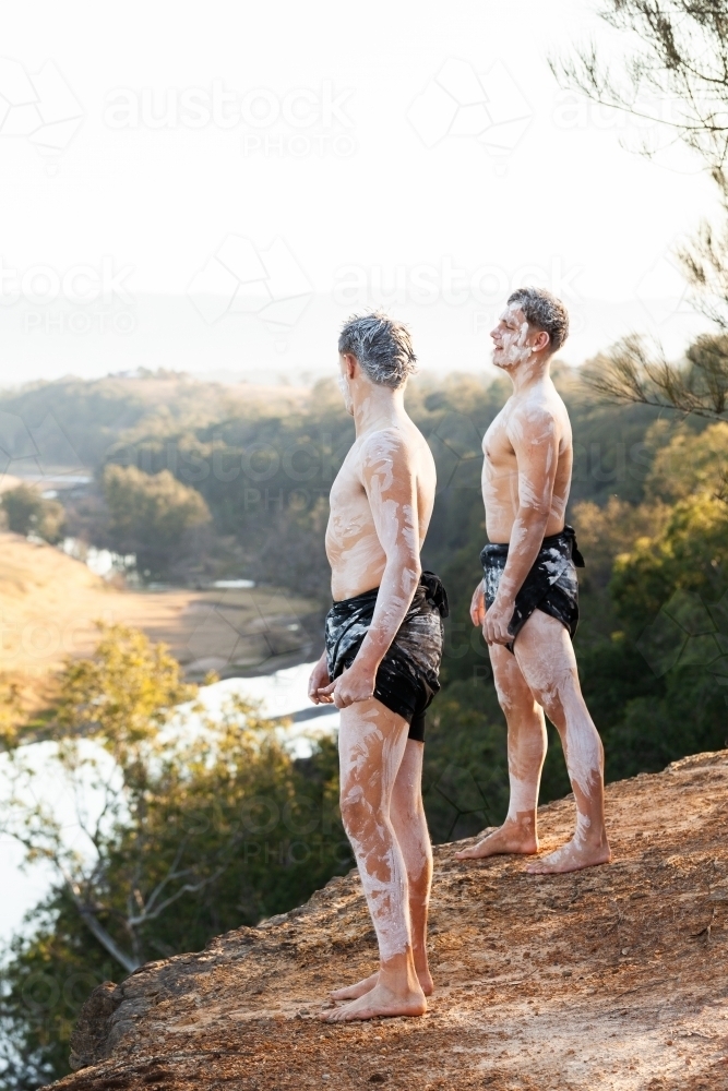 Image of Young First Nations men storytelling while on edge of cliff on ...