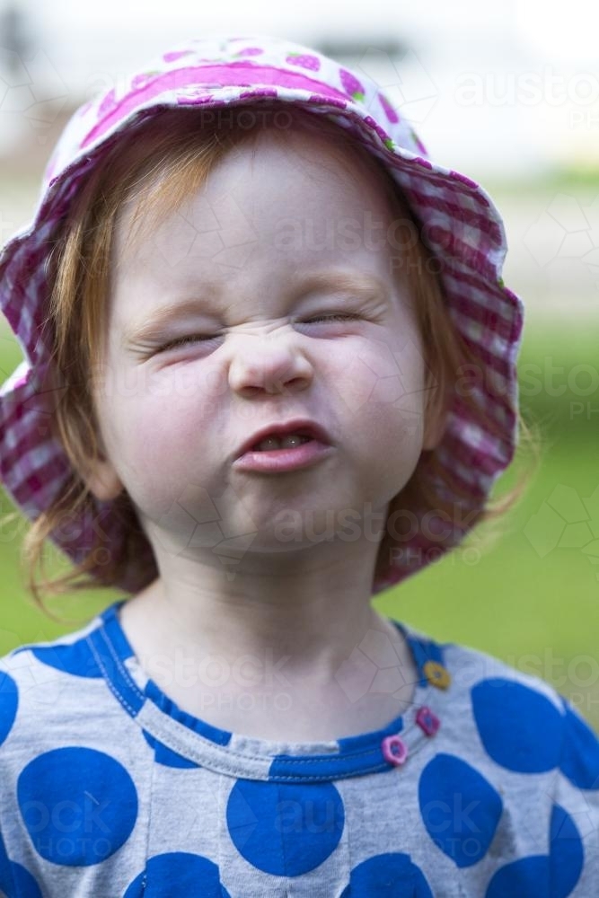 Image of Young girl attempts a wrinkle nose smile - Austockphoto