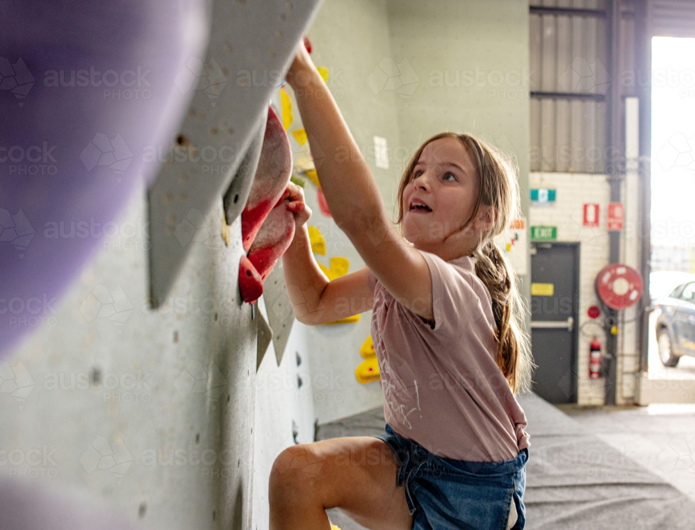 Image of Young girl climbing the bouldering walls - Austockphoto