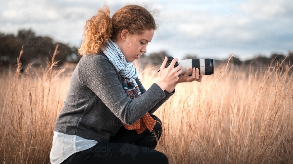 Image of Young girl profile holding camera - Austockphoto