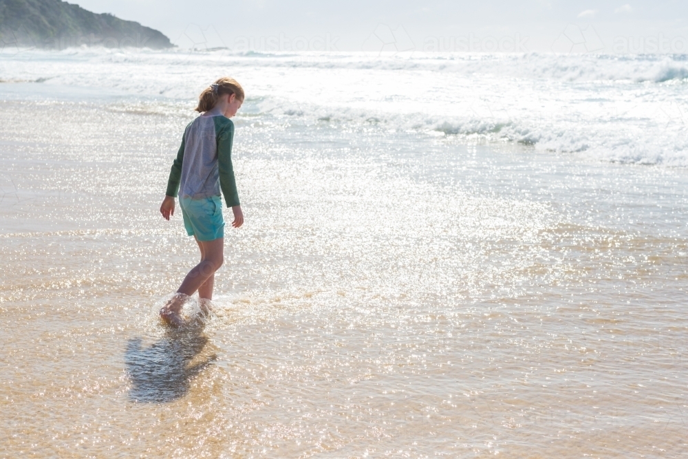 Image of Young girl walking into the water at Blueys beach - Austockphoto