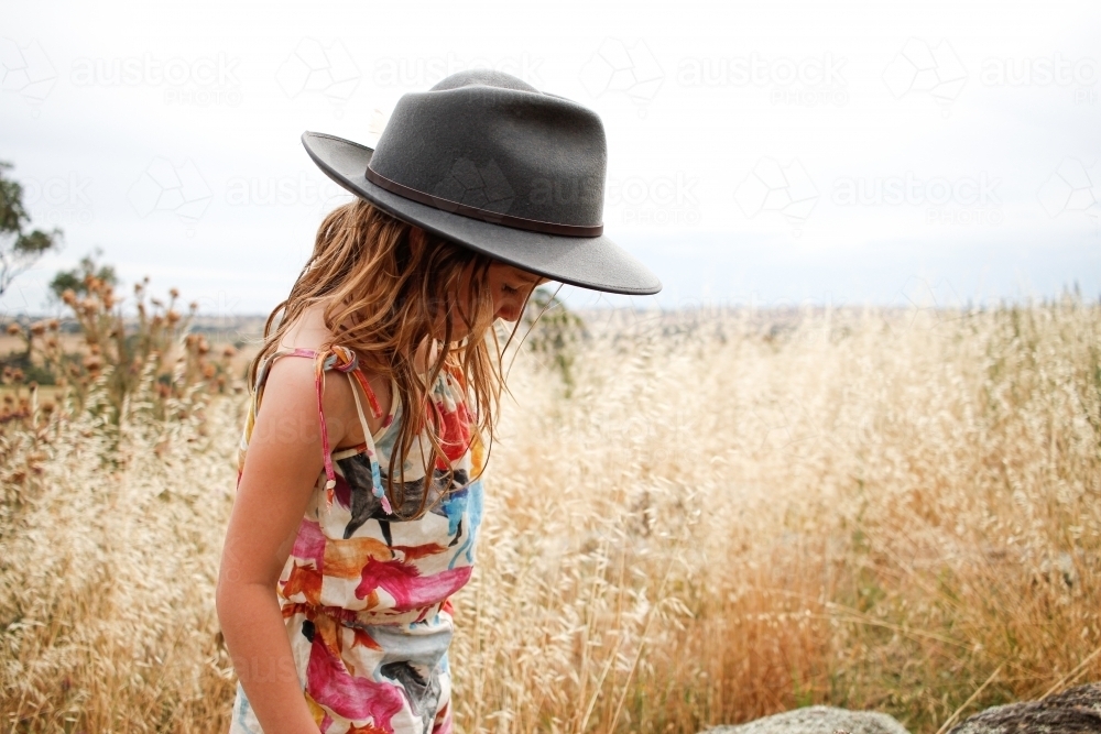 Image of Young girl wearing grey bushman's hat in grassy fields ...