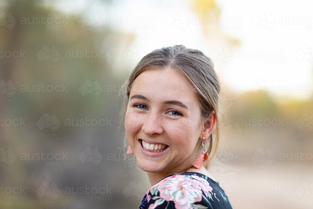 Image of Young lady standing outdoors smiling - Austockphoto