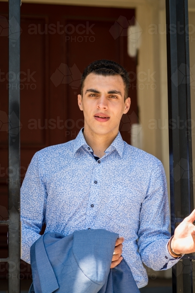 Image of young man leaving house - Austockphoto