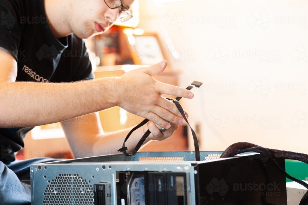 Image of Young man pulling apart and re-building home computer ...
