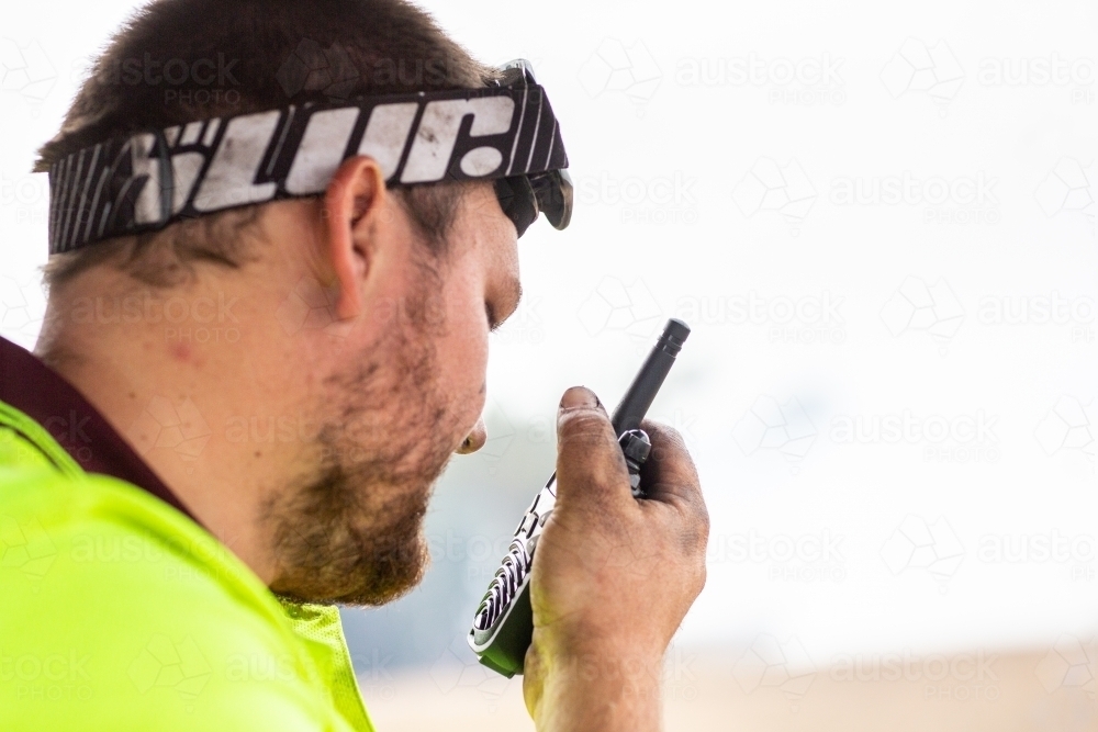 Image of Young man taking on walky-talky two way radio - Austockphoto