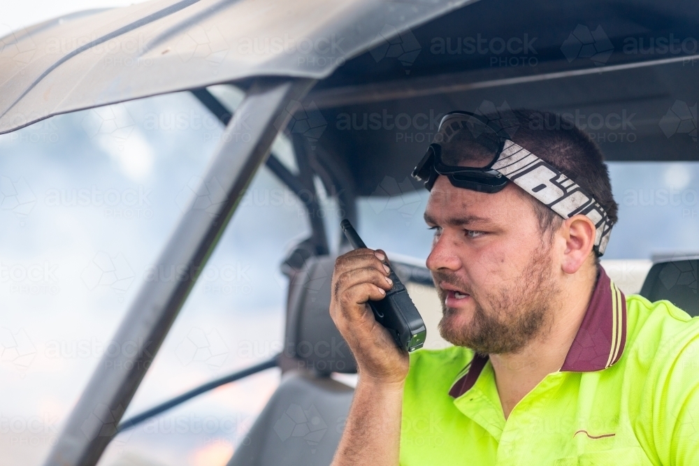 Image of Young man talking on walkie-talkie two way radio - Austockphoto